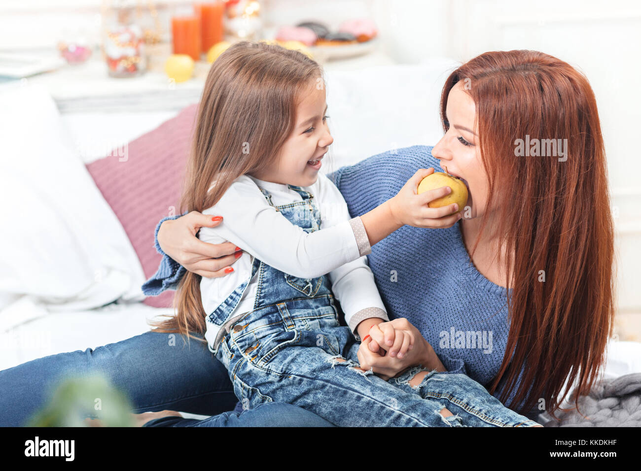 A little cute girl enjoying, playing and creating with apple with ...