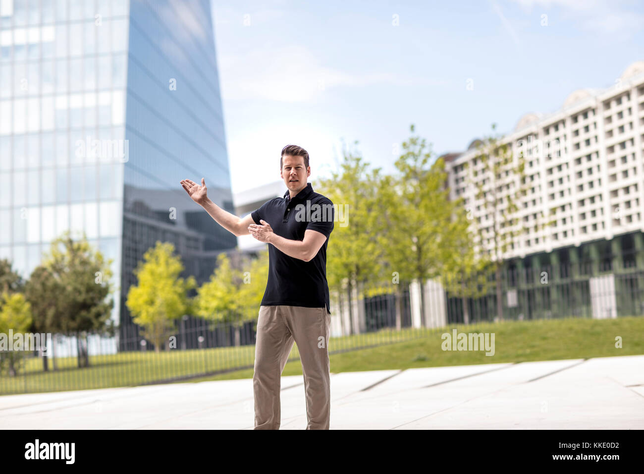 A man making demonstrative hand gestures while standing in front of ...