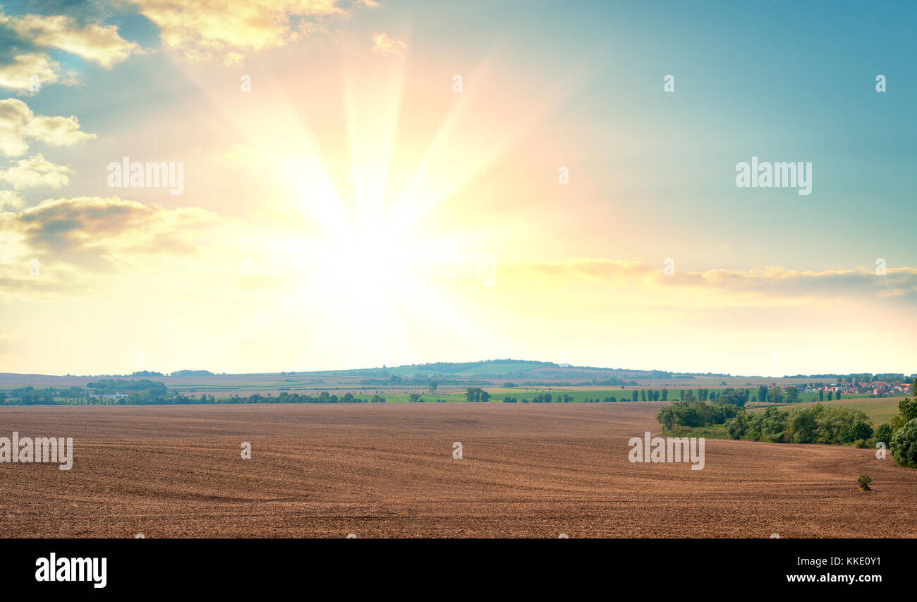 Sunrise over fields and distant woods Stock Photo - Alamy