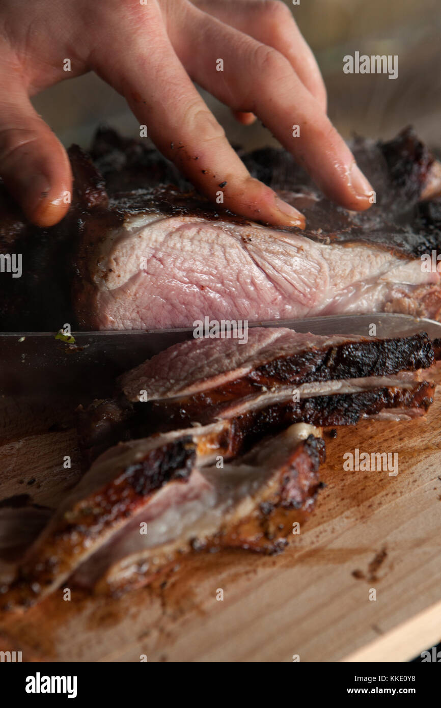 A chef slices lamb which has been roasted over an open fire Stock Photo ...