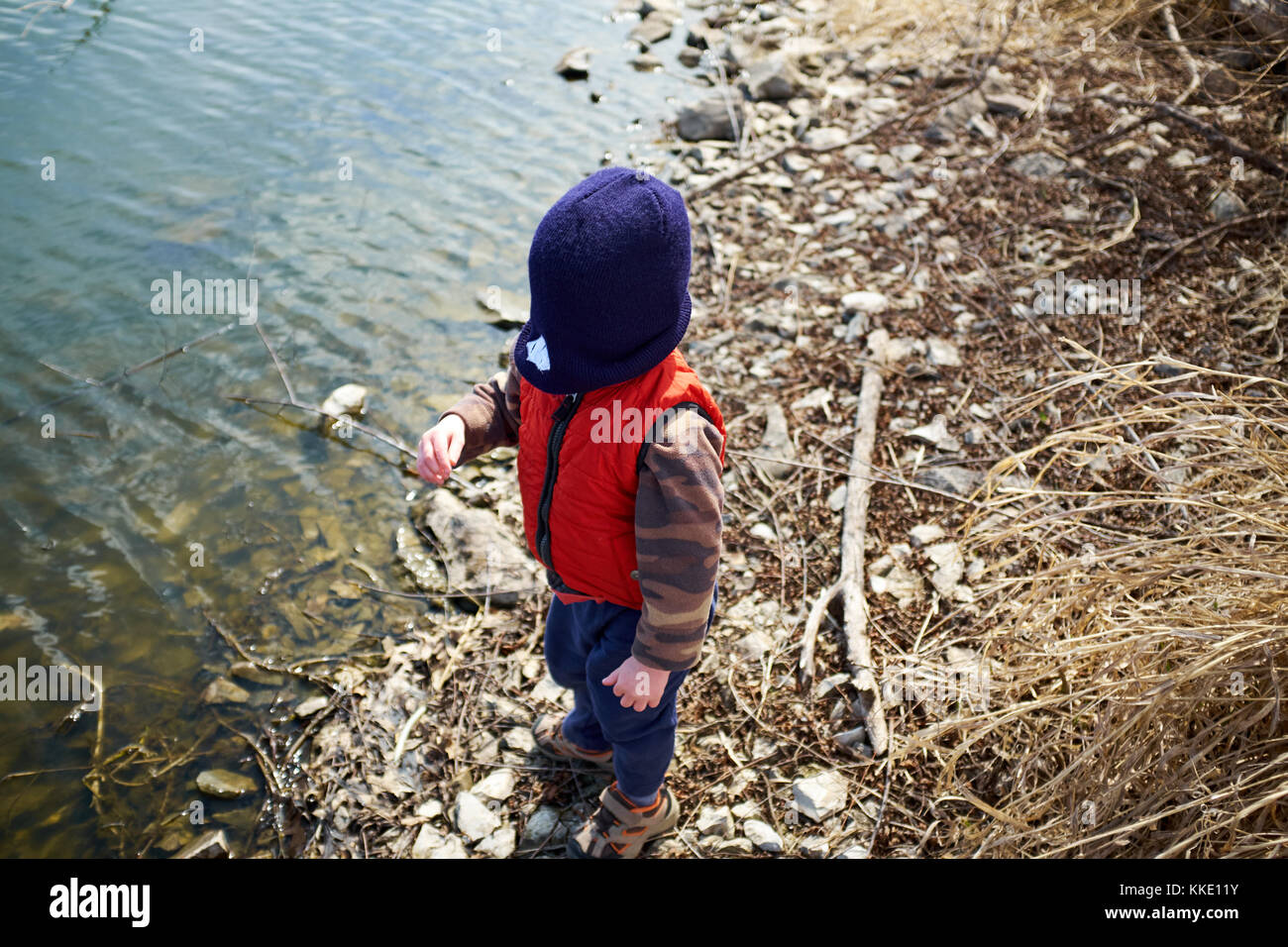 High angle view of young child wearing cap standing by water Stock ...