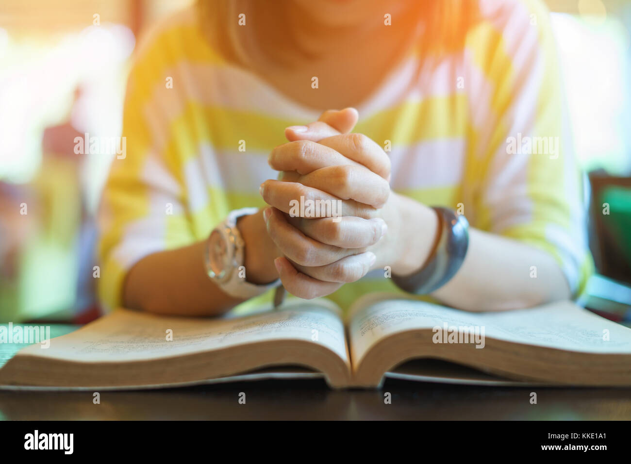 woman praying on holy bible in the morning. teenager hand with Bible praying,Hands folded in ...