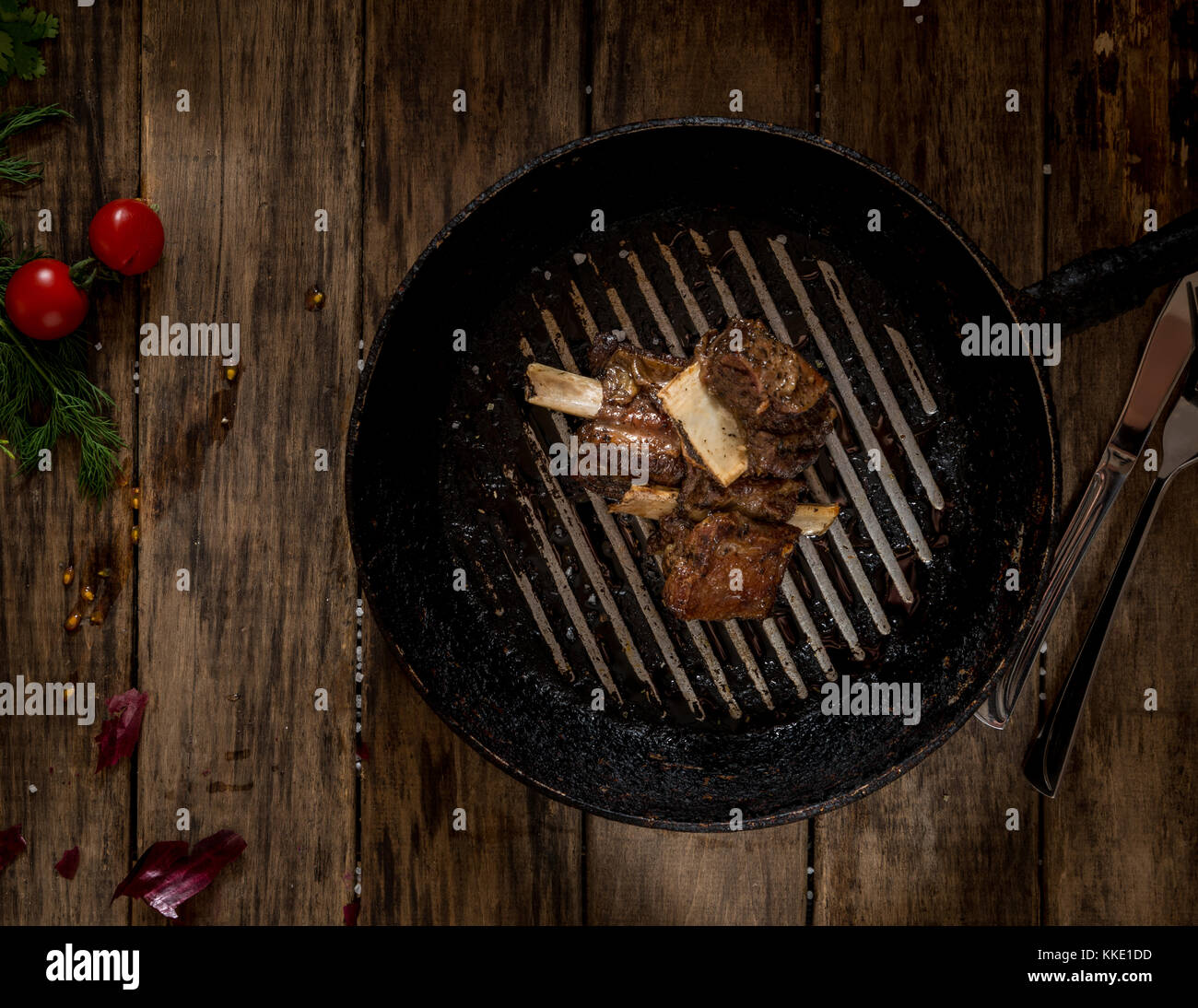 in old pan fried meat with bone on wooden background, top view Stock ...