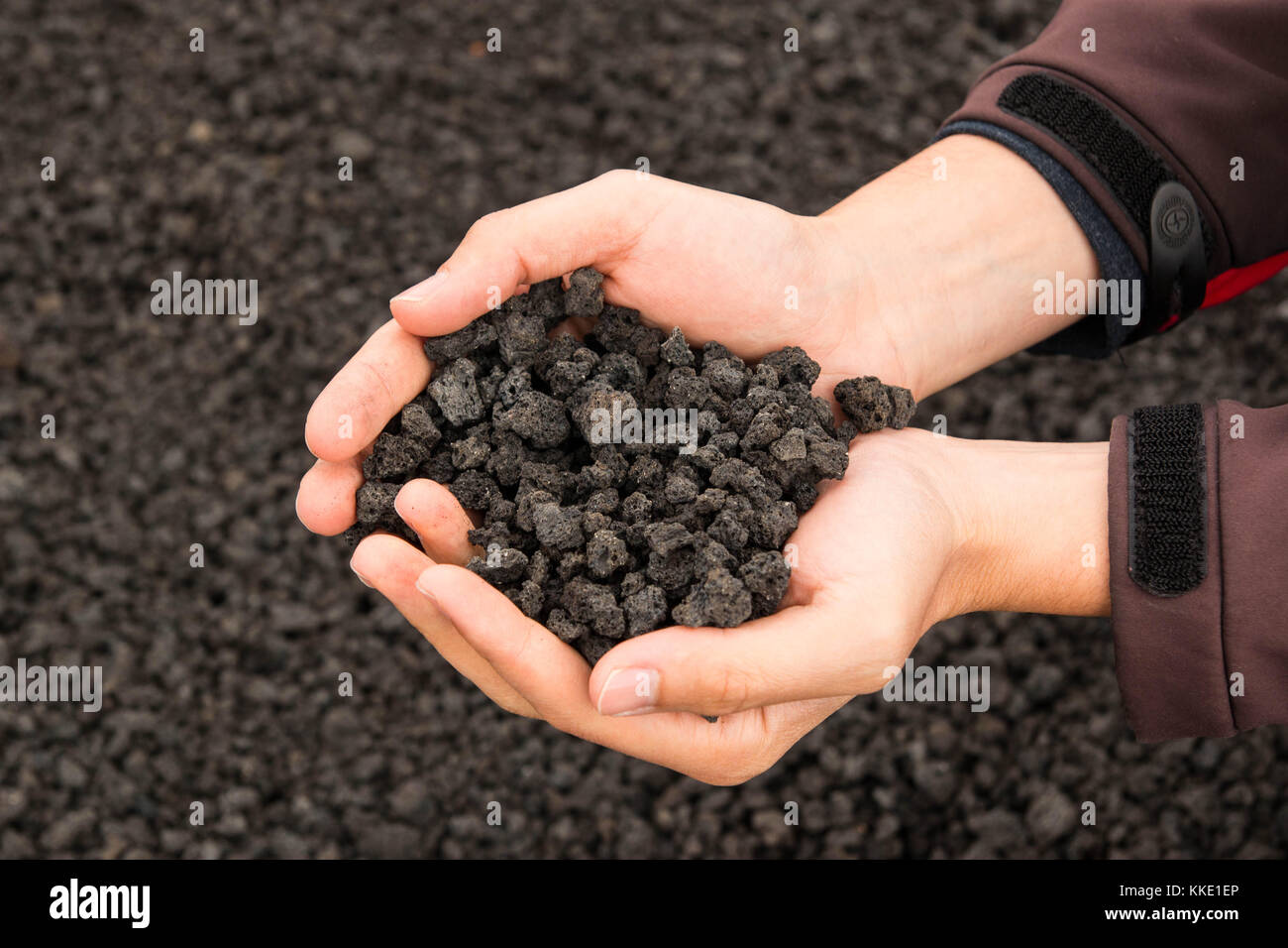 Hands holding cold lava rocks. Etna volcano, Sicily Stock Photo - Alamy