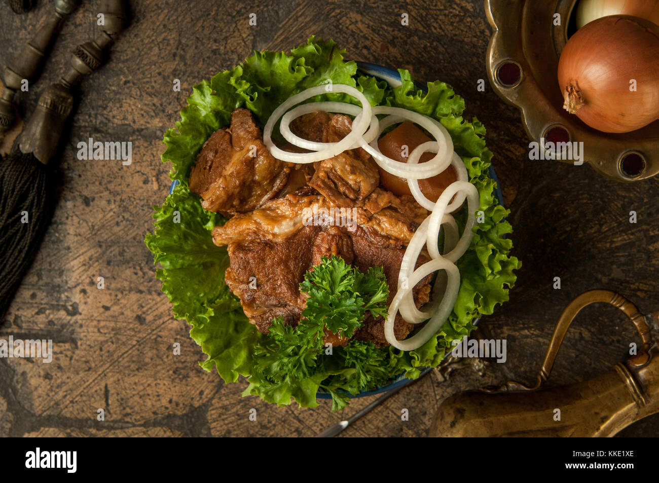 oriental dishes on decorative old tiles. fried meat and jug on ...