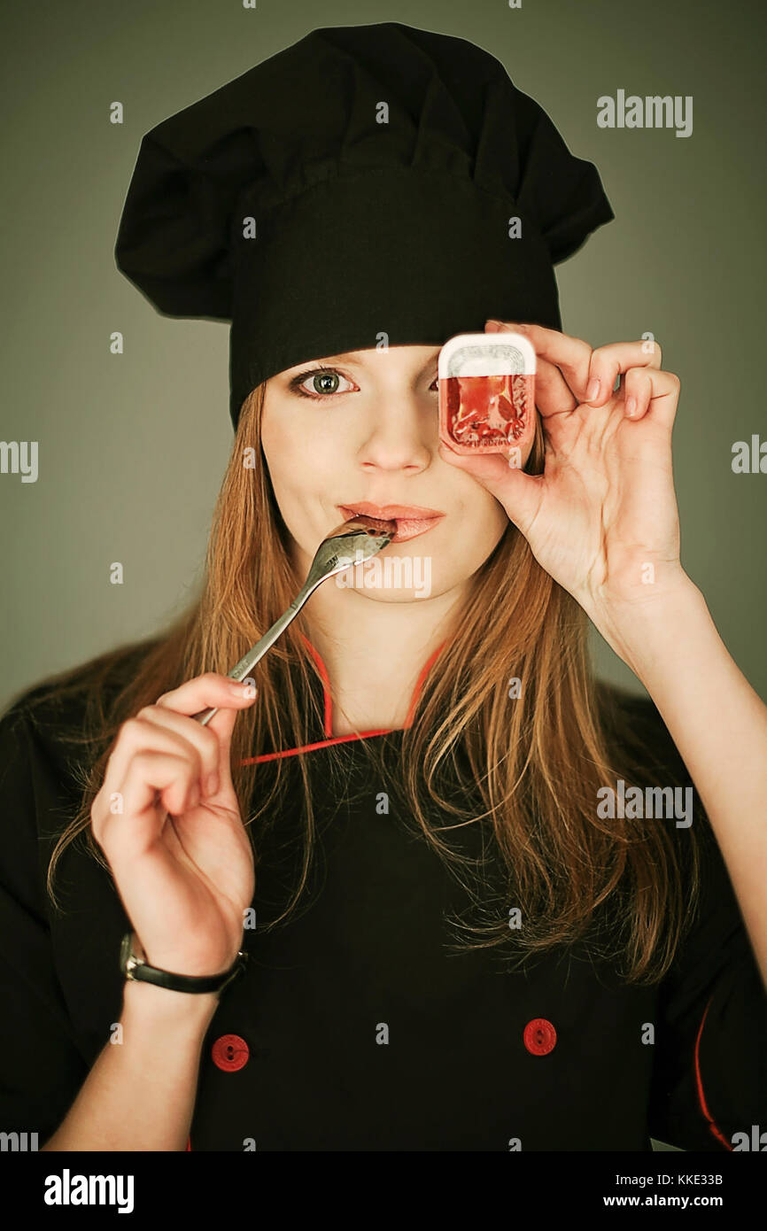 Funny portrait of a joyful lady cook with box of sauce and a metal ...