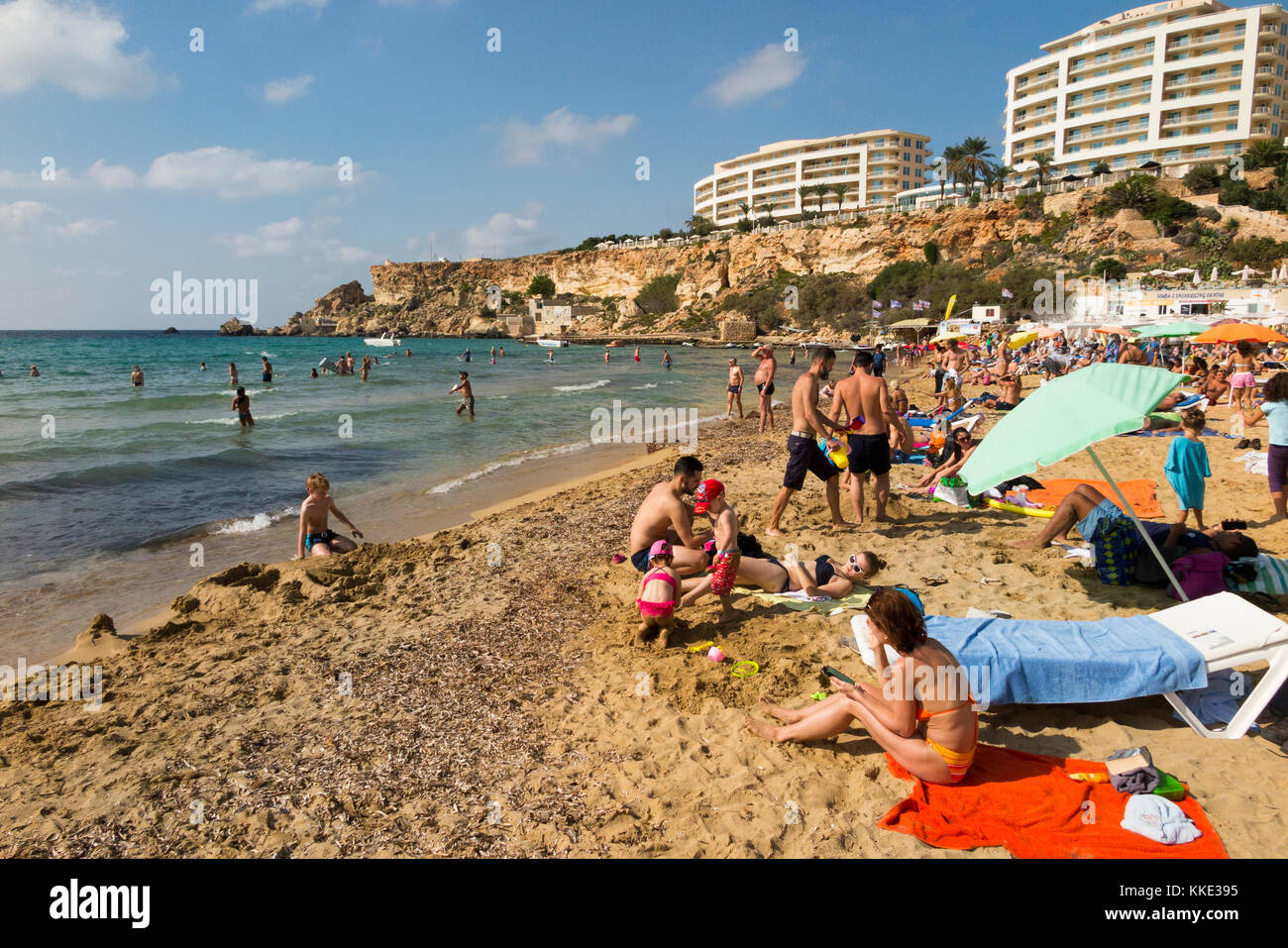 Sea & sandy beach with tourists / sunbathers people enjoying themselves ...
