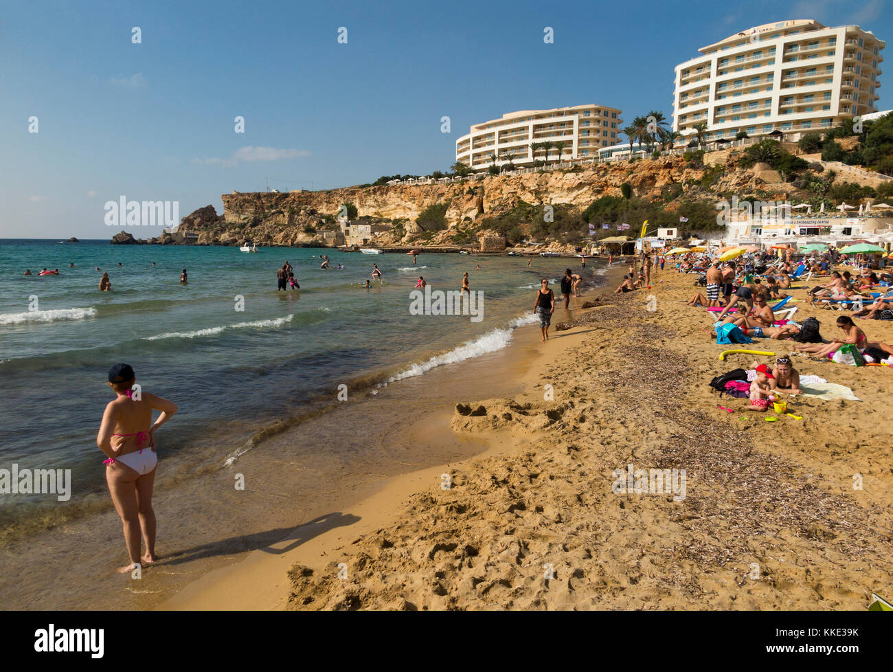 Sea & sandy beach with tourists / sunbathers people enjoying themselves ...
