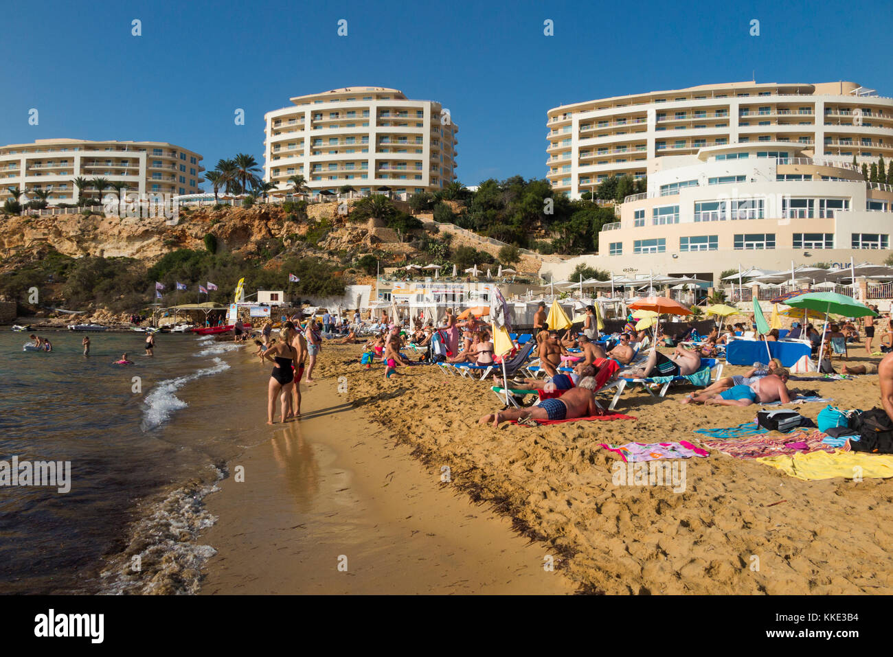 Sea & sandy beach with tourists / sunbathers people enjoying themselves ...