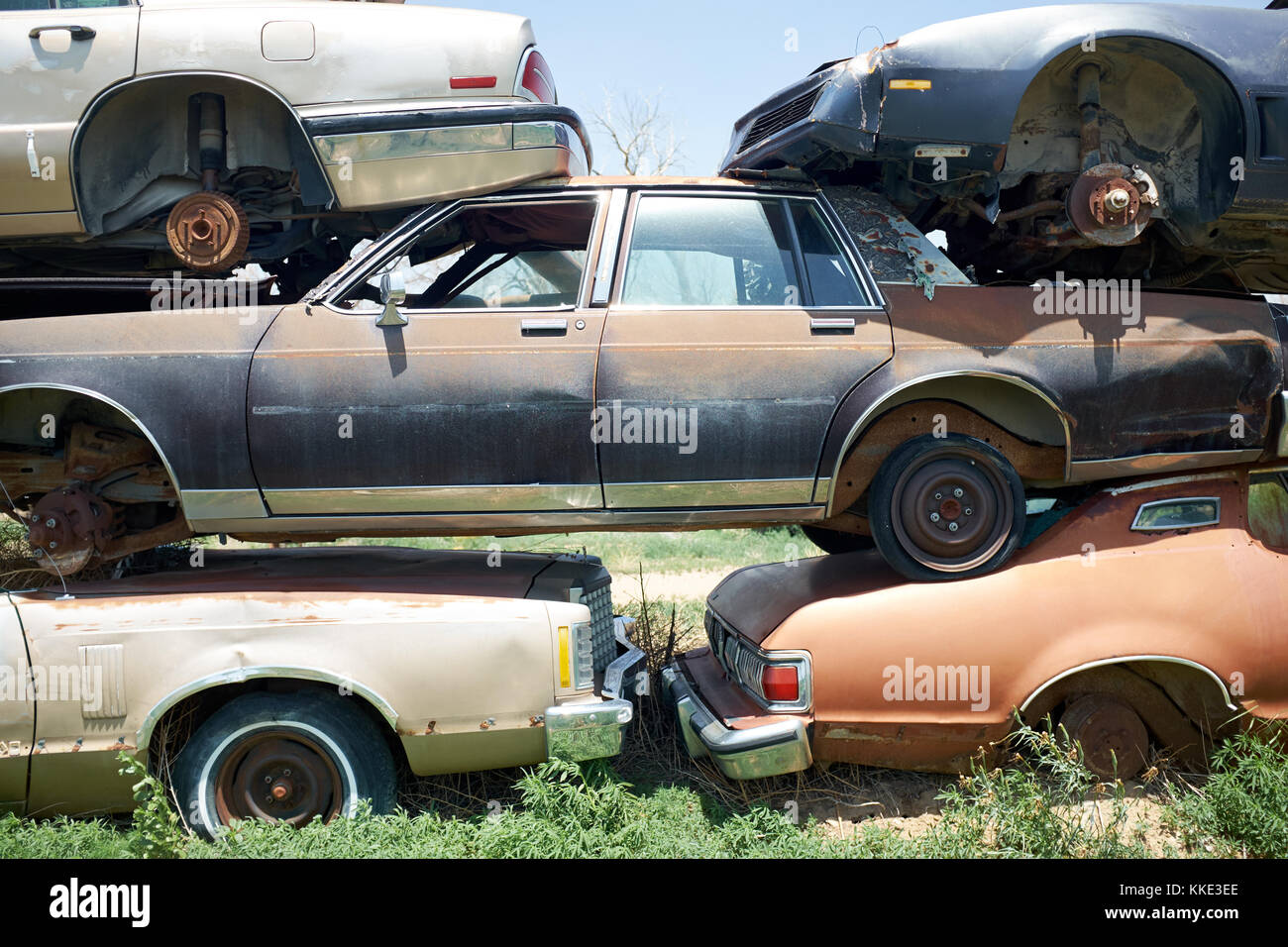 Stack of old rusting cars in a breakers yard or scrap yard neatly piled ...