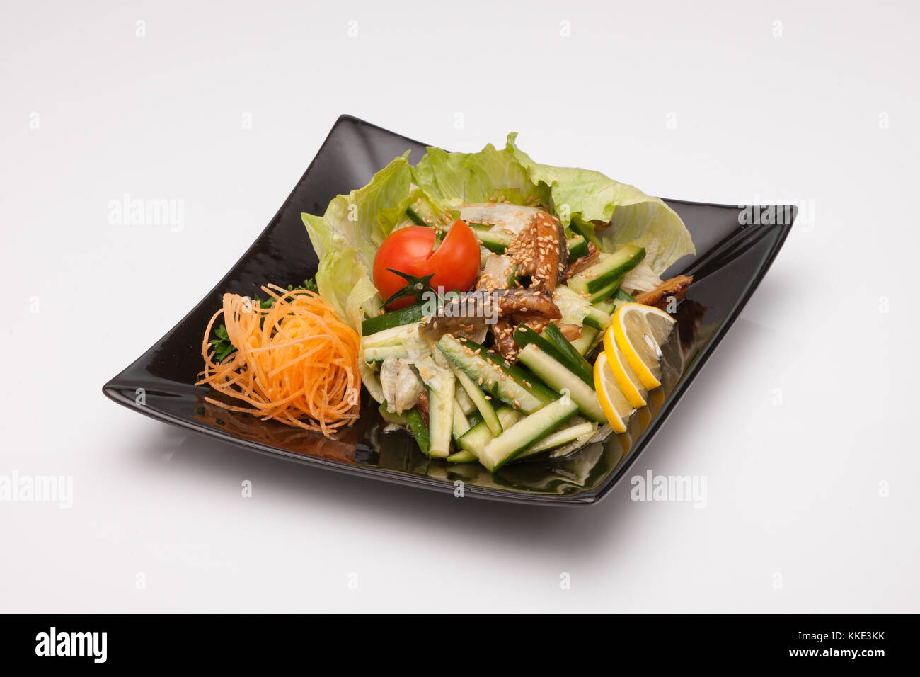 Vegetable salad in black square plate on a light background Stock Photo ...