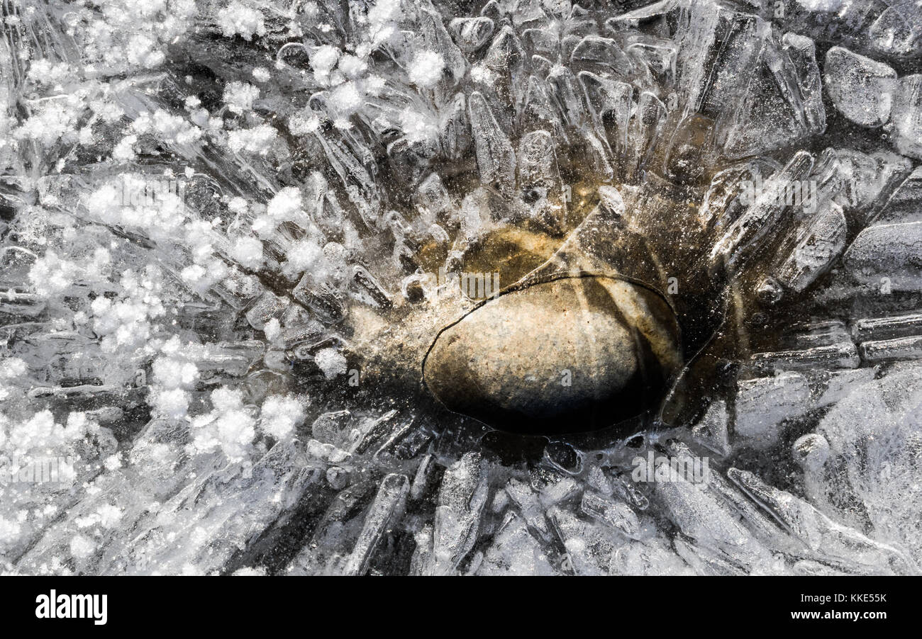 Small rock breaking through ice Stock Photo - Alamy