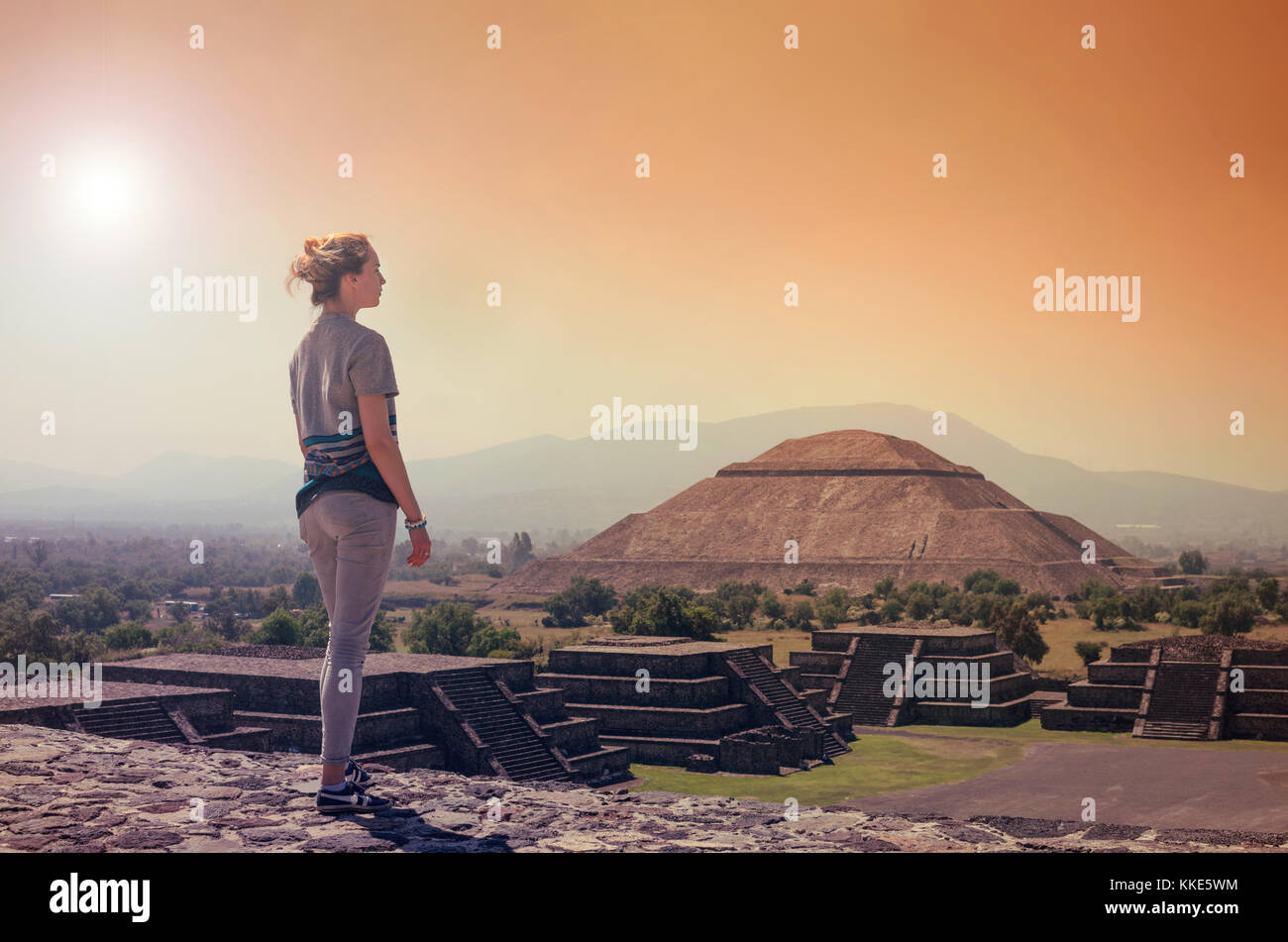 Young woman standing on top of pyramid and overlooking Teotihuacan in ...