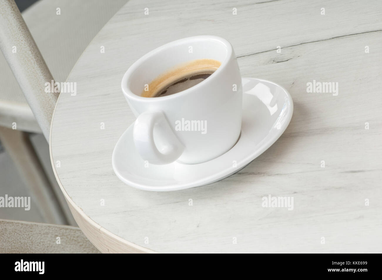 Coffee cup and saucer on a round table Stock Photo - Alamy
