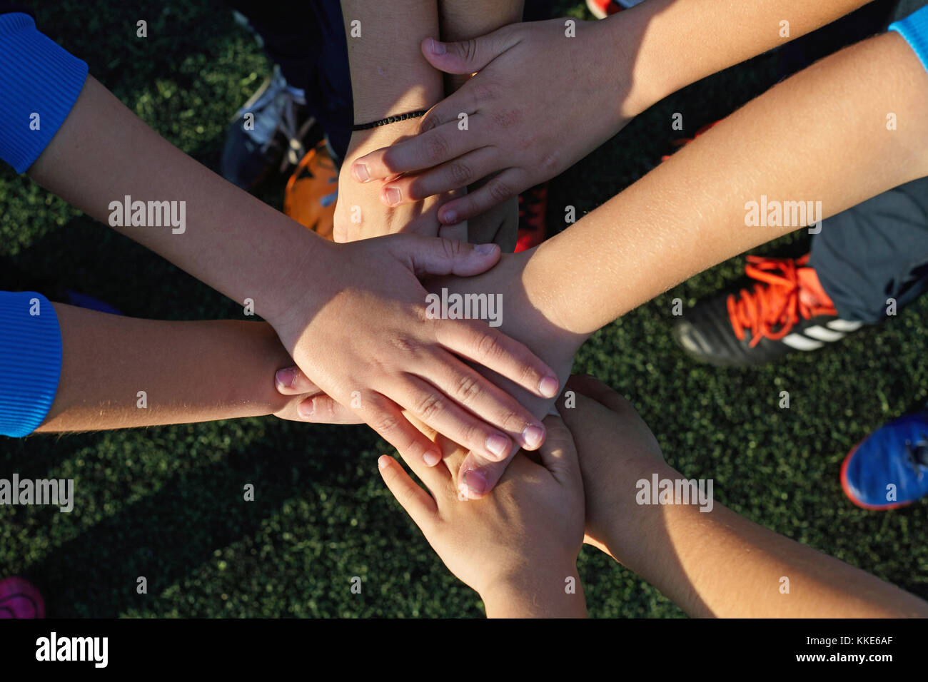 Close-up of many children's hands holding together as a football team ...