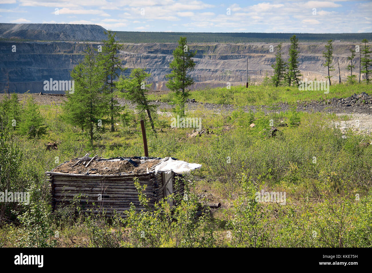 Rustic wooden hut and massive open mine at the background Stock Photo ...