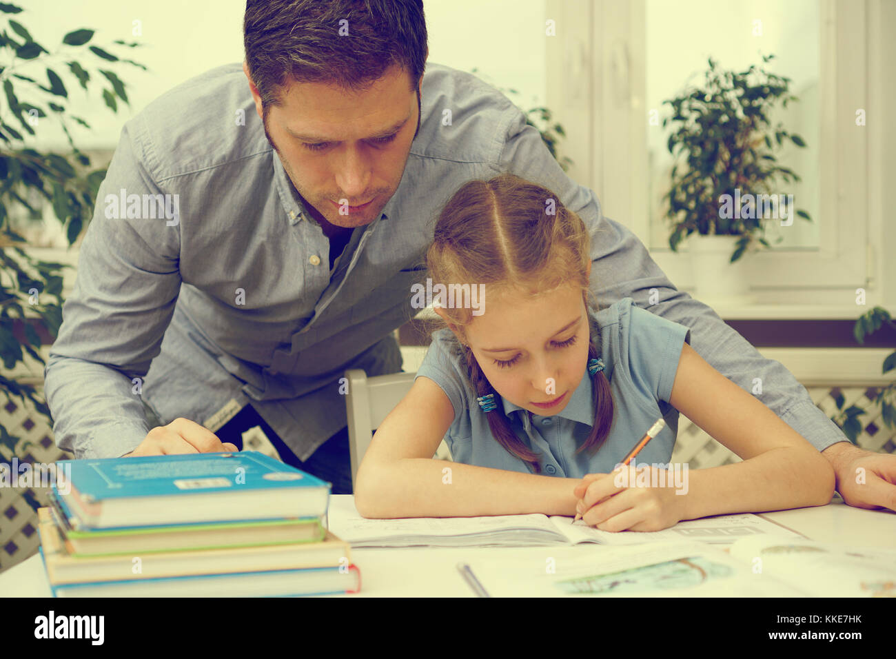 Father helping daughter with homework at home Stock Photo - Alamy