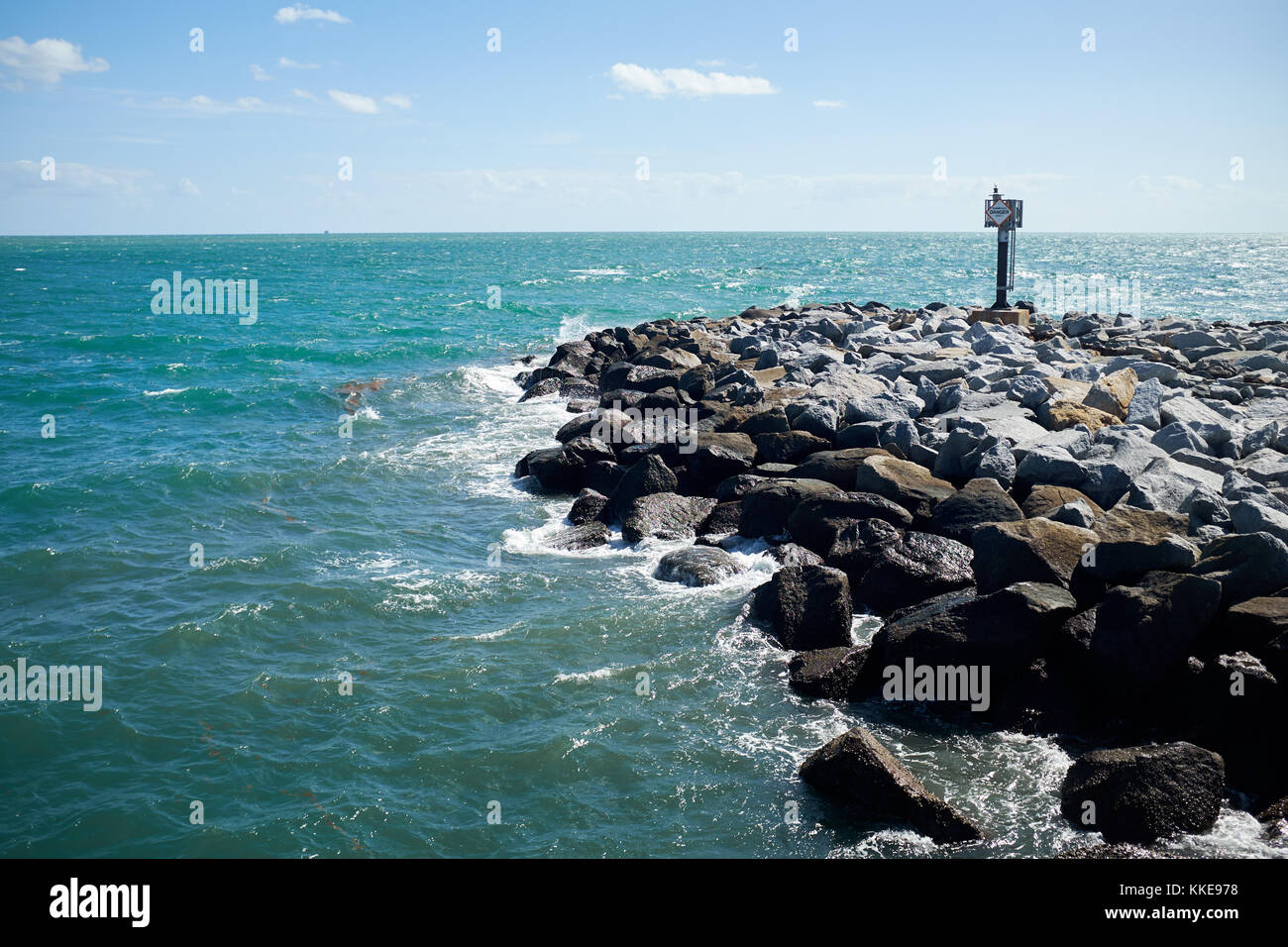 Beacon at the end of a rocky breakwater or sea wall in Florida, part of ...