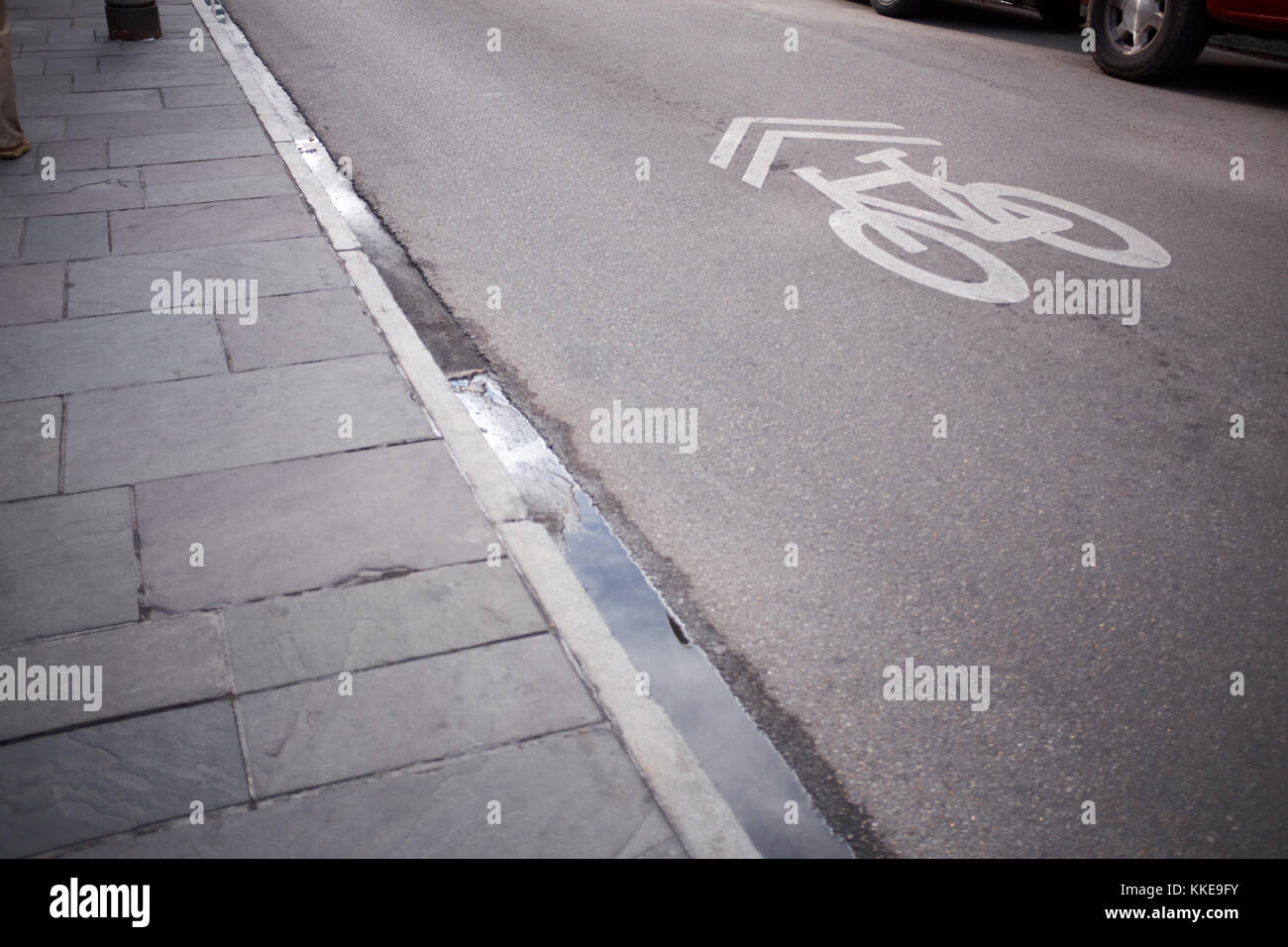 Painted bicycle sign on an asphalt street with arrows denoting a cycle ...