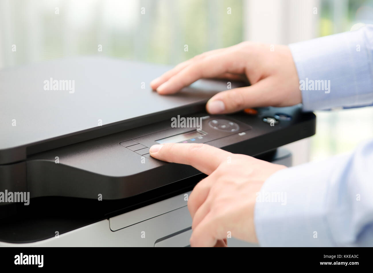 Hand press button on panel of printer. printer scanner laser office ...