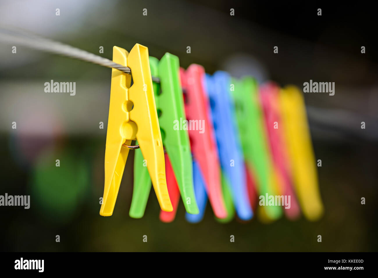 Colorful pegs hanging on clothesline Stock Photo - Alamy
