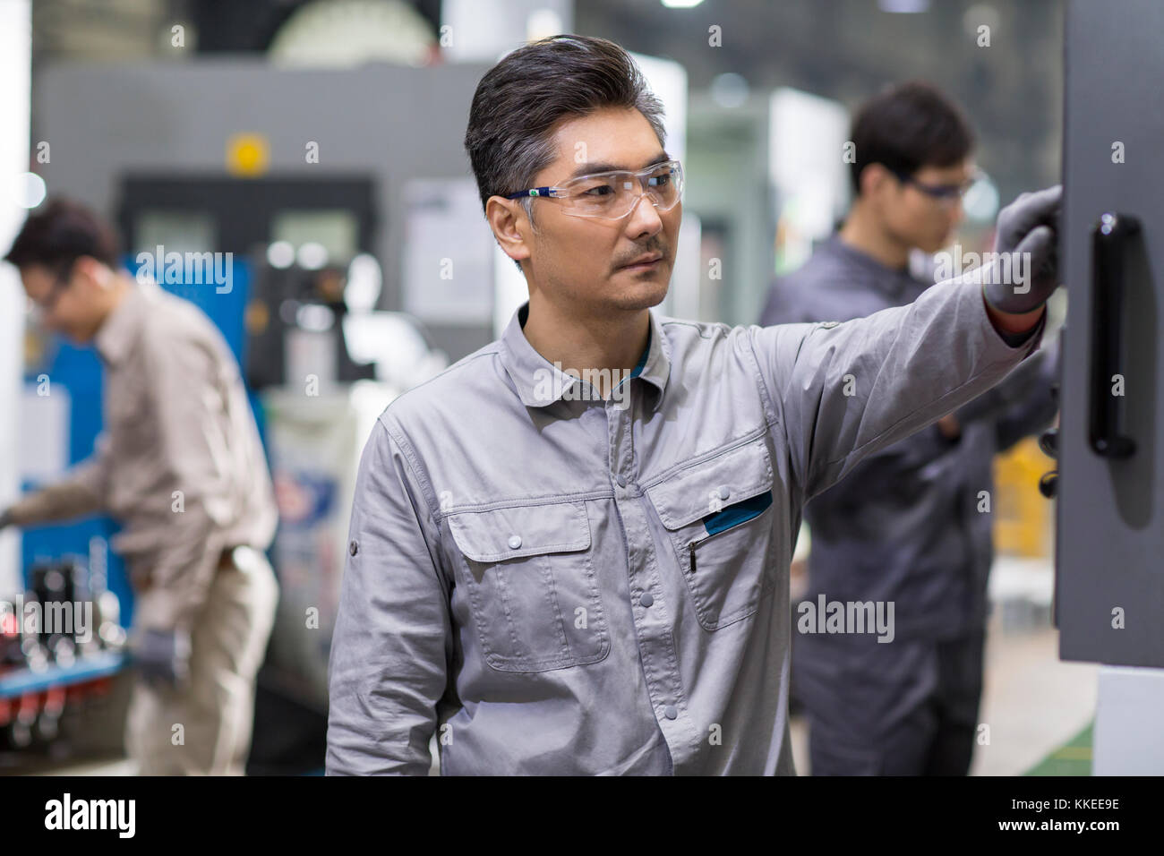 Confident Chinese engineers working in the factory Stock Photo - Alamy