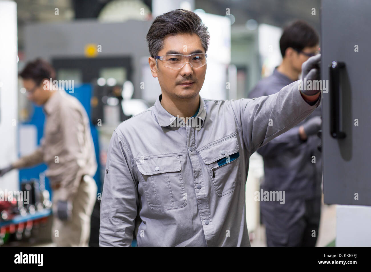 Confident Chinese engineers working in the factory Stock Photo - Alamy