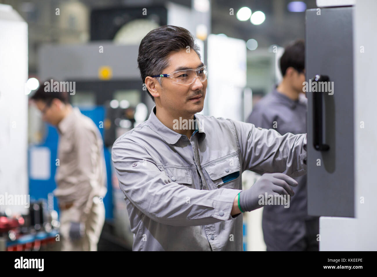 Confident Chinese engineers working in the factory Stock Photo - Alamy
