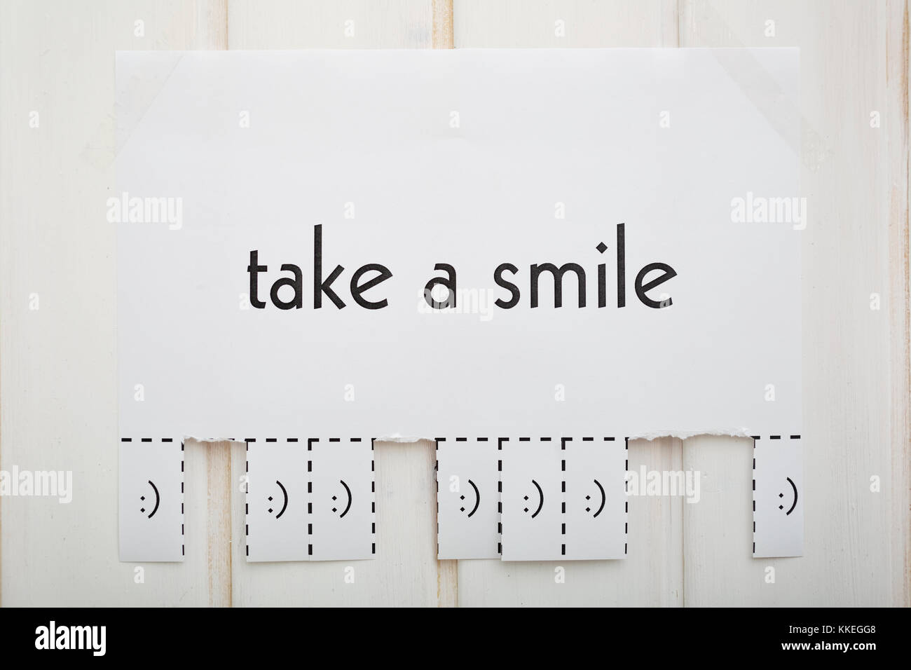 A paper with the phrase: Take a Smile and with a smile sign ready to be ...