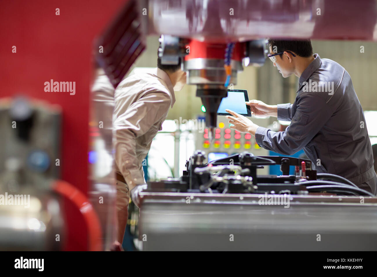 Young Chinese engineers talking in the factory Stock Photo - Alamy