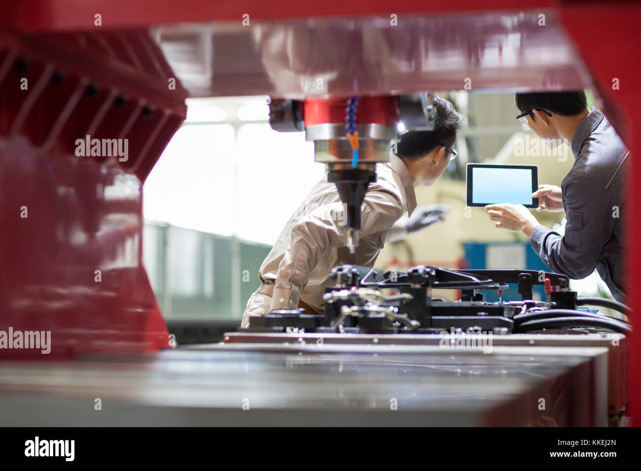 Young Chinese engineers talking in the factory Stock Photo - Alamy
