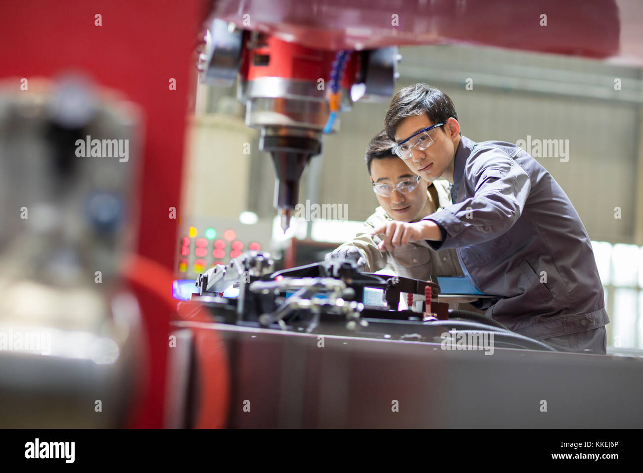 Young Chinese engineers checking machine in the factory Stock Photo - Alamy