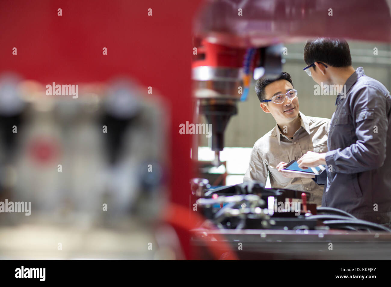 Young Chinese engineers talking in the factory Stock Photo - Alamy