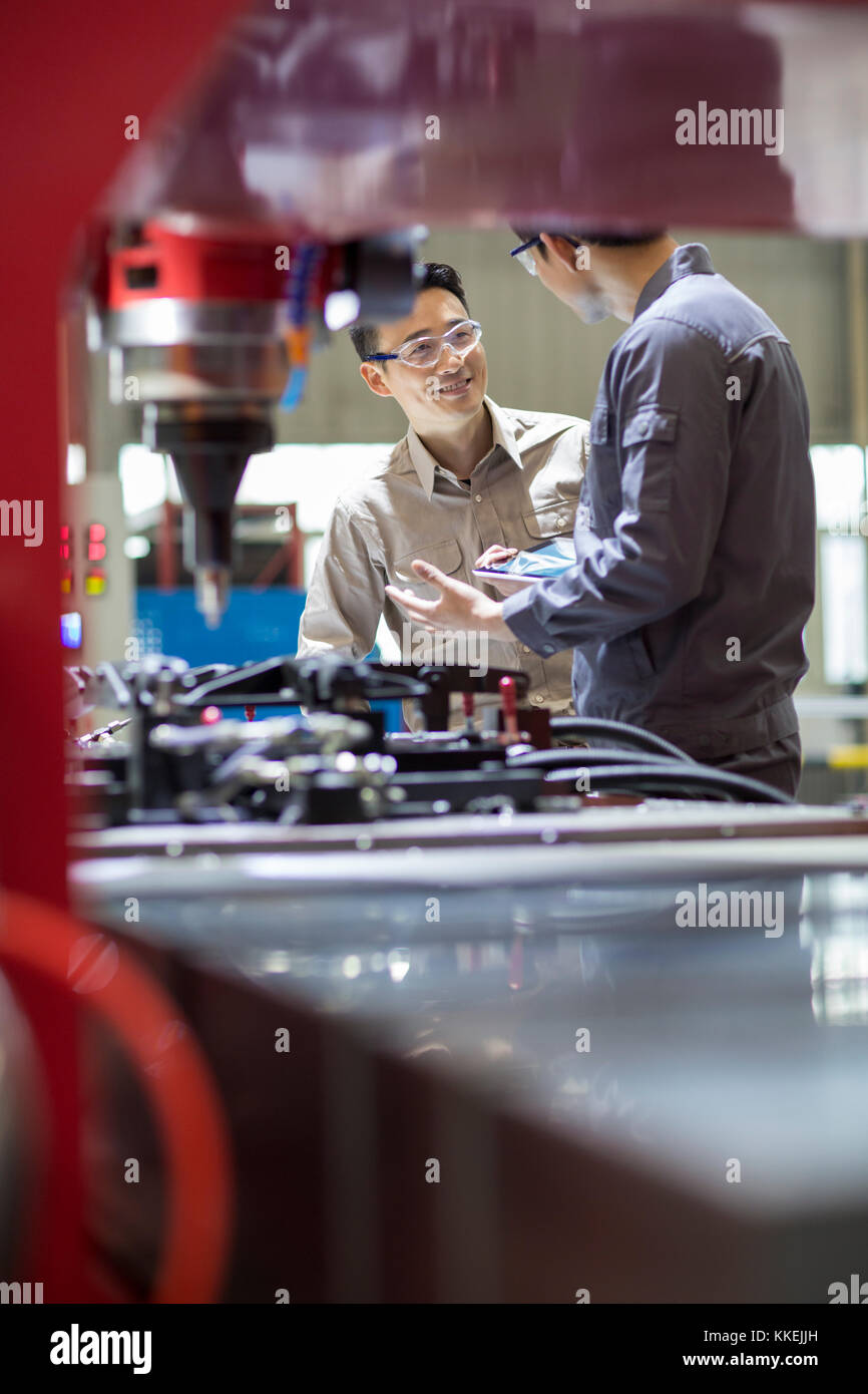 Young Chinese engineers talking in the factory Stock Photo - Alamy