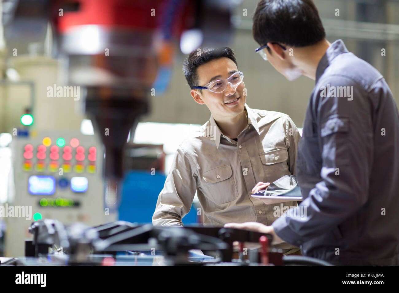 Young Chinese engineers talking in the factory Stock Photo - Alamy