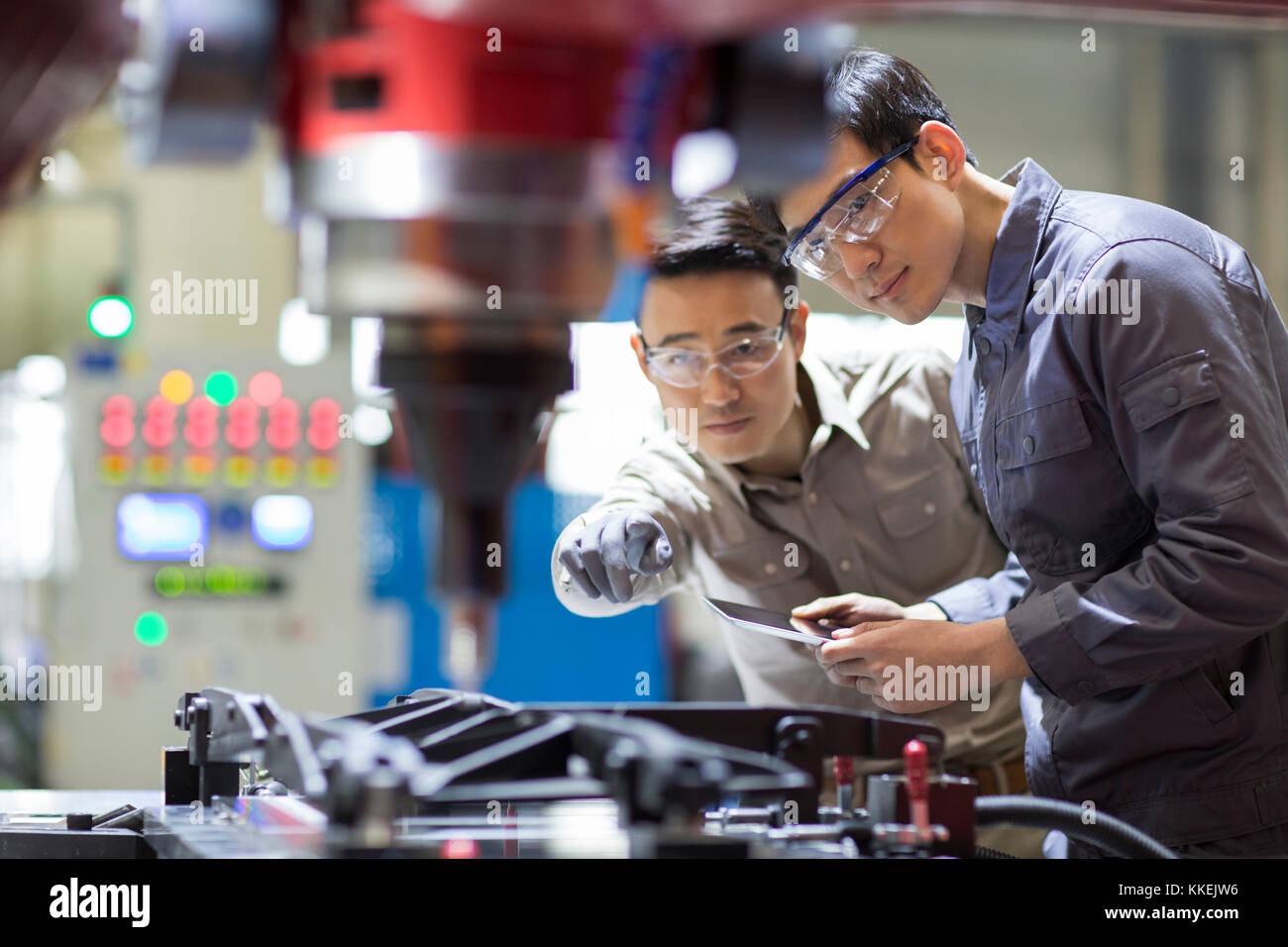Young Chinese engineers checking machine in the factory Stock Photo - Alamy