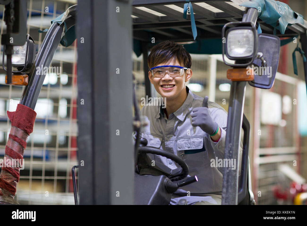 Young Chinese workman driving forklift in the factory Stock Photo - Alamy