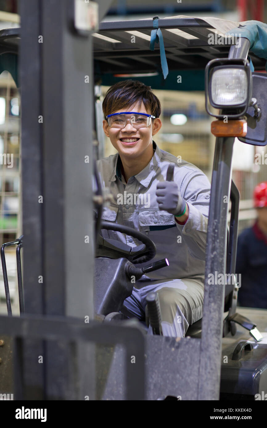 Young Chinese workman driving forklift in the factory Stock Photo - Alamy