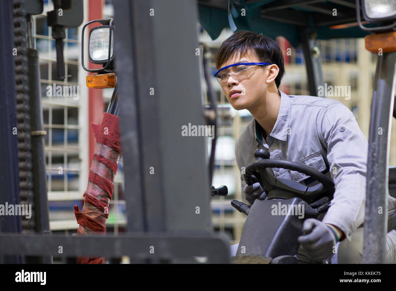Young Chinese workman driving forklift in the factory Stock Photo - Alamy