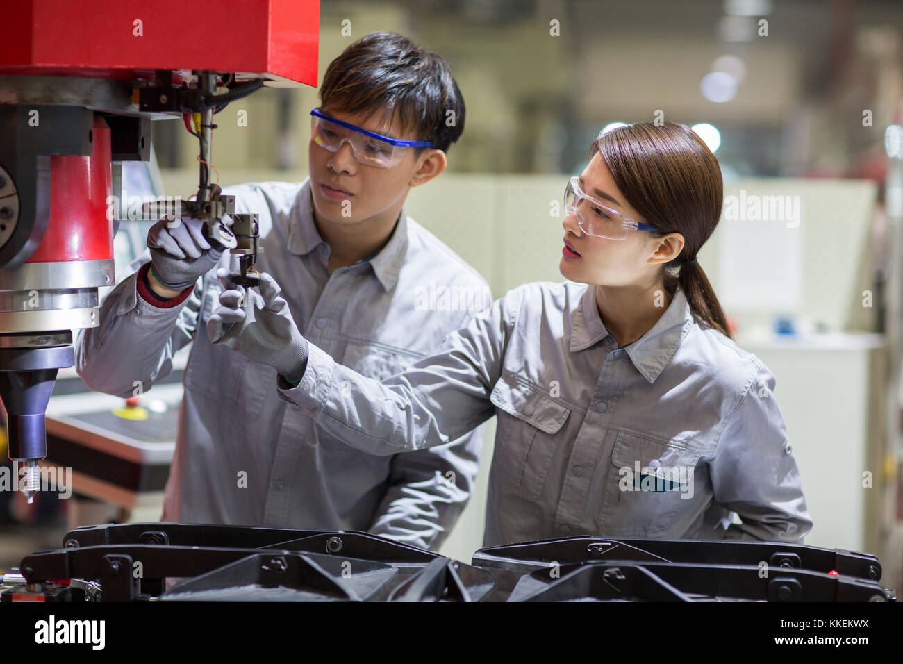 Young Chinese engineers checking machine in the factory Stock Photo - Alamy