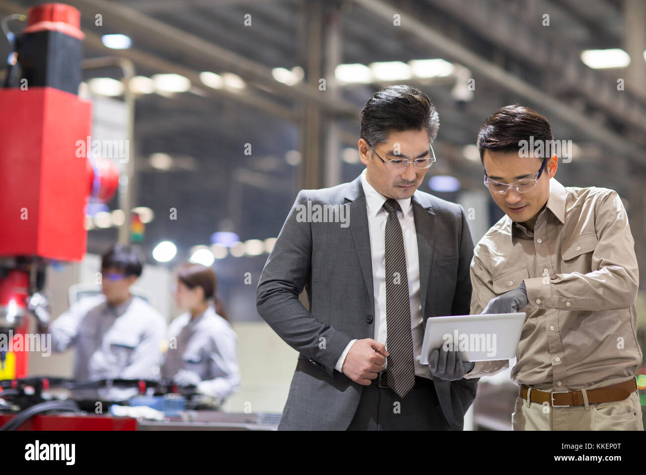 Chinese businessman and engineer talking in the factory Stock Photo - Alamy