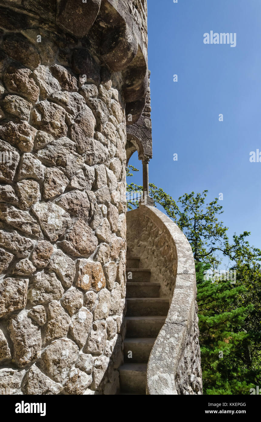Narrow outer spiral stairs that go around old tower made of natural ...