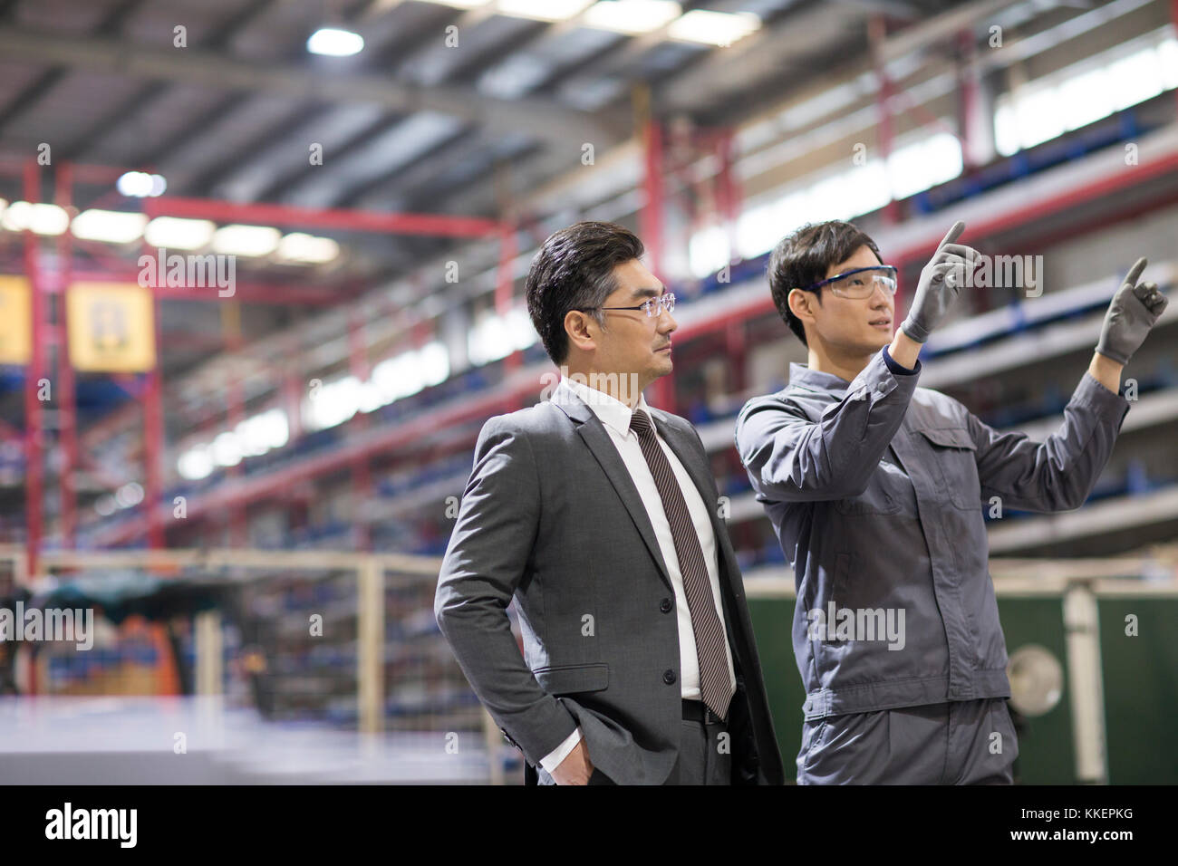 Chinese businessman and engineer talking in the factory Stock Photo - Alamy