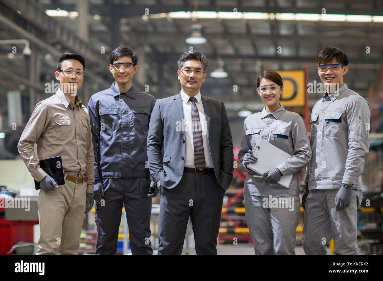 Confident Chinese businessman and engineering team in the factory Stock ...
