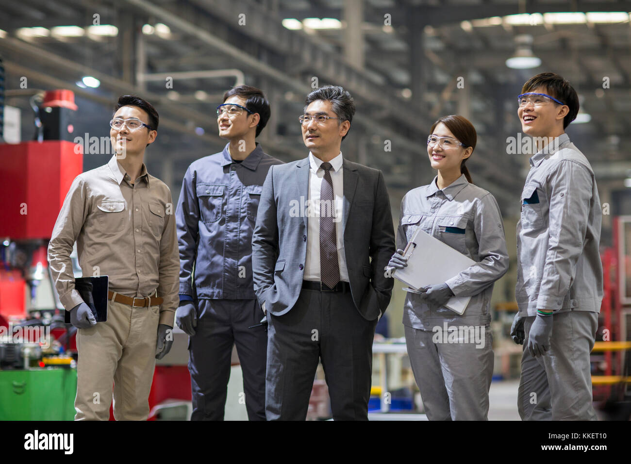 Confident Chinese businessman and engineering team in the factory Stock ...