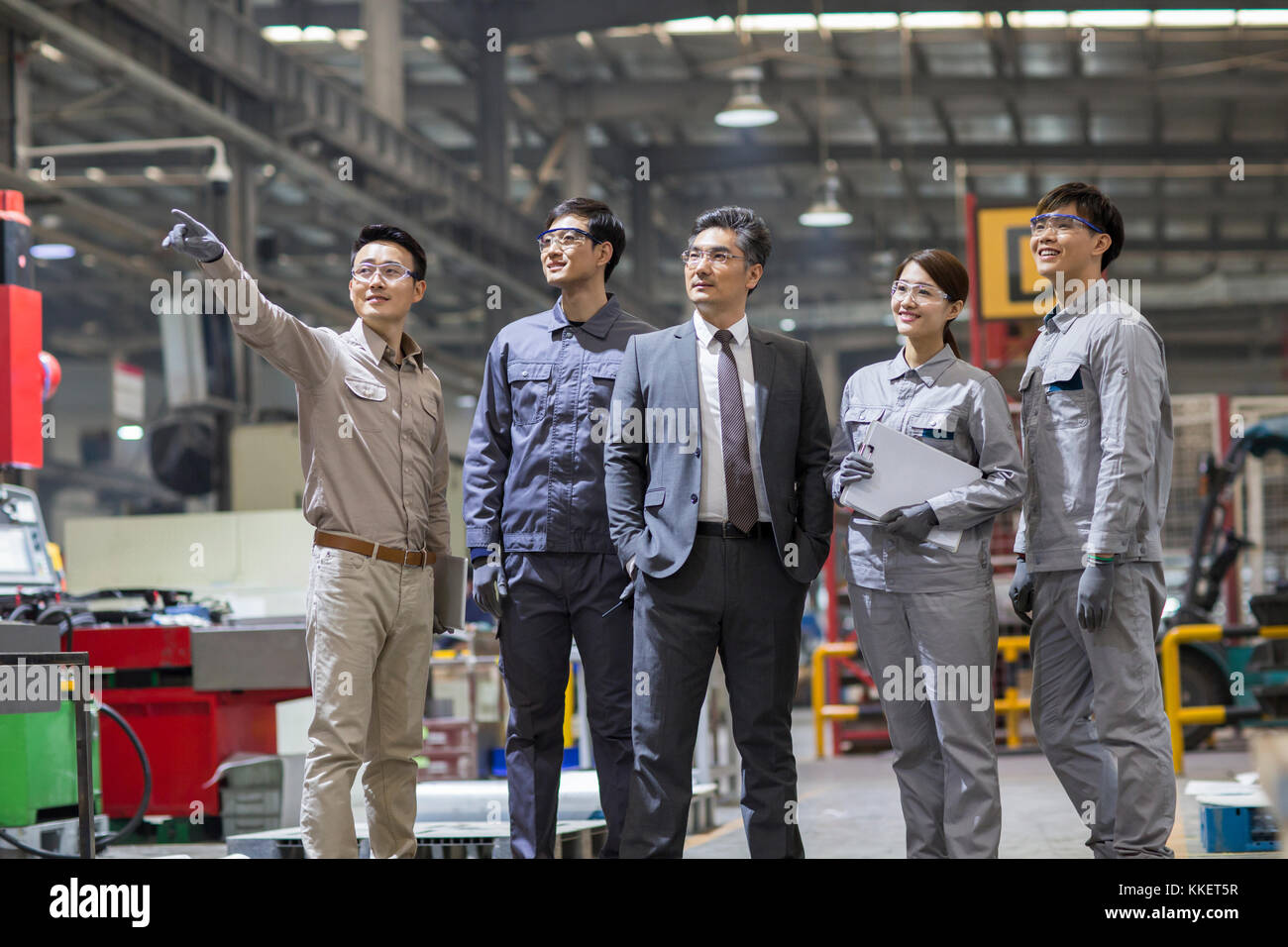 Confident Chinese businessman and engineering team in the factory Stock ...