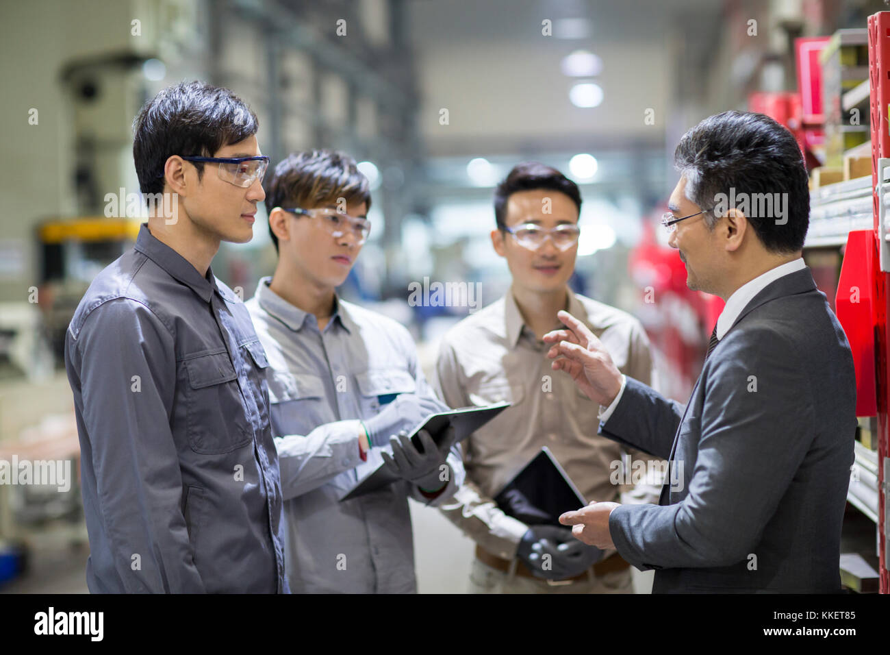 Chinese businessman and engineers talking in the factory Stock Photo ...