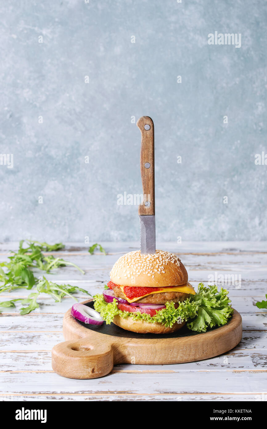 Homemade burger in classic bun with tomato sauce, arugula, meat, cheese ...