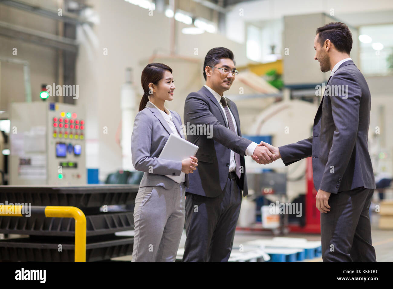 Business people shaking hands in the factory Stock Photo - Alamy