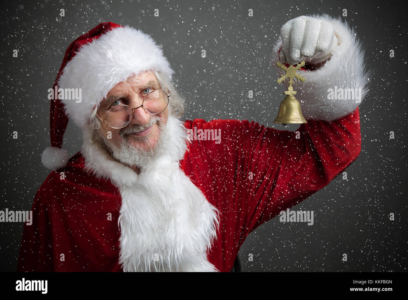 Jingle bells. Santa Claus holding metal bell in his hand and against ...